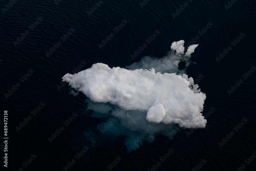 Melting sea ice, broken off from the ice shelf, floating in the arctic ...