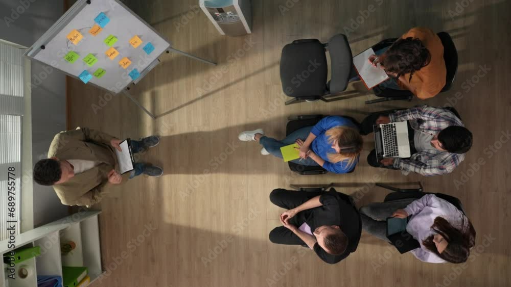 In the shot above, a group of people and a coach, a mentor. He is ...