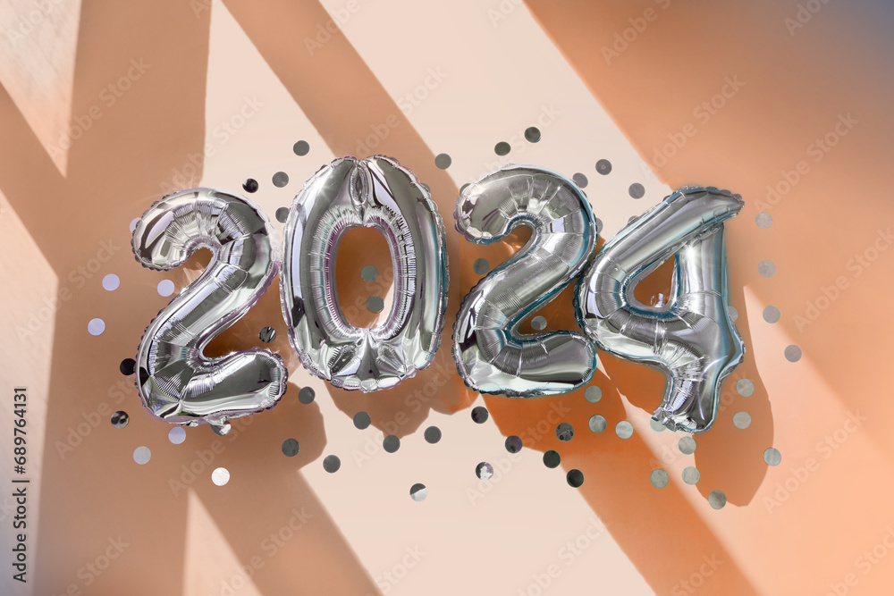 Silver numbers 2024 new year balloons among confetti in sunlight on ...