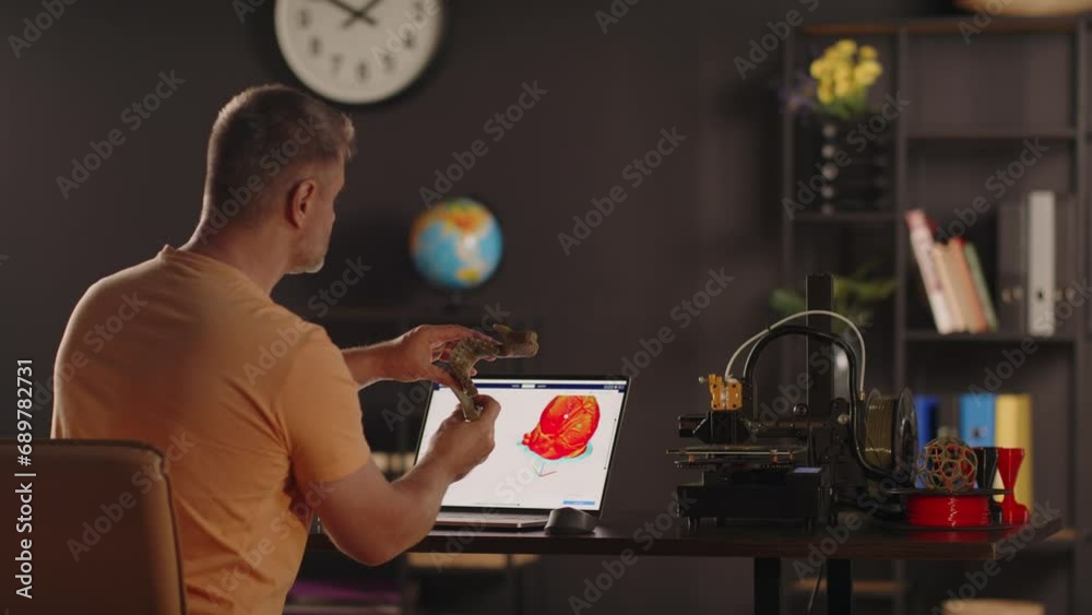 A man graphic designer holds plastic 3d printed model of human mandible ...
