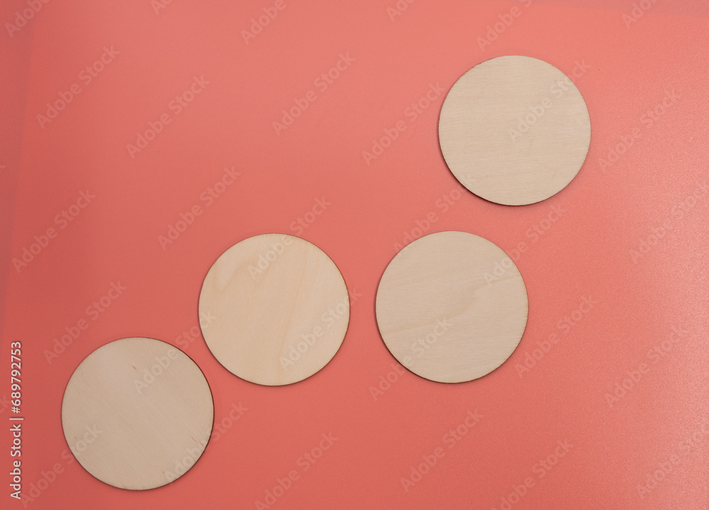 Wooden disks on a pink background with room for copy or graphics. Three ...