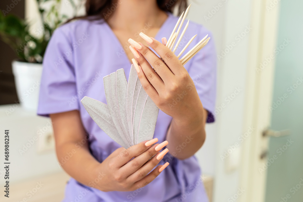 Portrait of a manicurist young girl holding nail file for processing ...