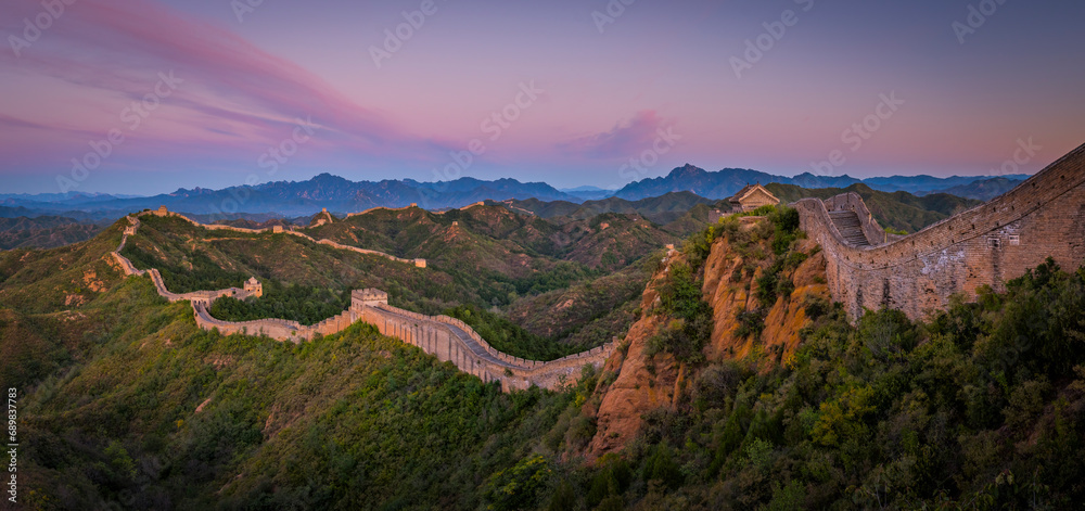Panoramic view of the Great Wall of China at sunset across the mountain ...