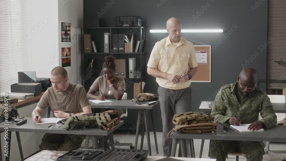 Full shot of Caucasian professor walking around classroom speaking and ...