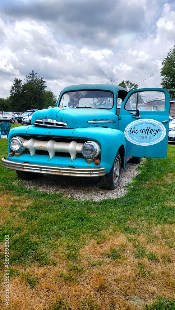 battered pickup truck of the 50s Ford F-100 advertises a local store ...