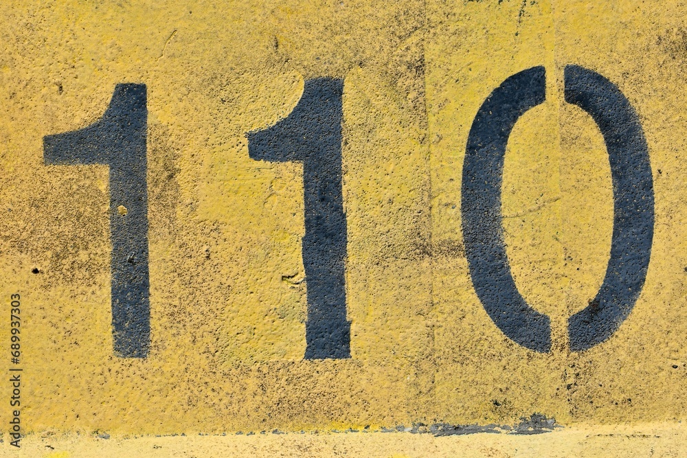 The number 110, one hundred and ten. one one zero; painted in black and ...