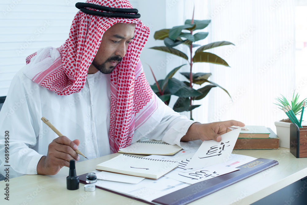 Arab business man use free time to practice Khat writing with bamboo ...