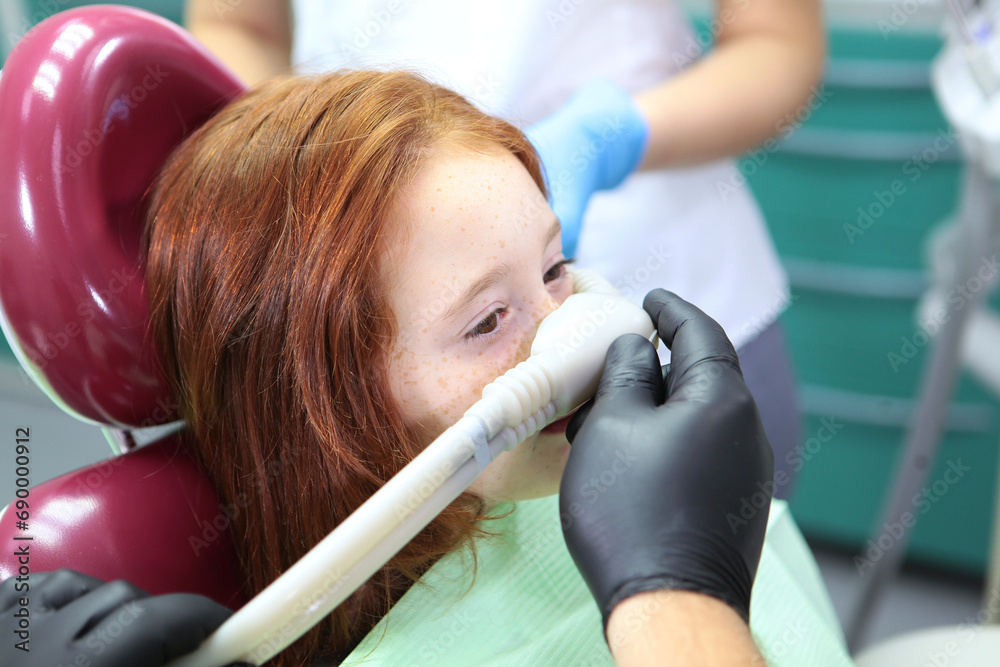 A little girl is injected with an inhalation sedative during dental ...