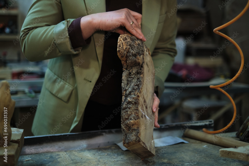Hands hold a slab of burl wood with intricate grain, highlighting the ...