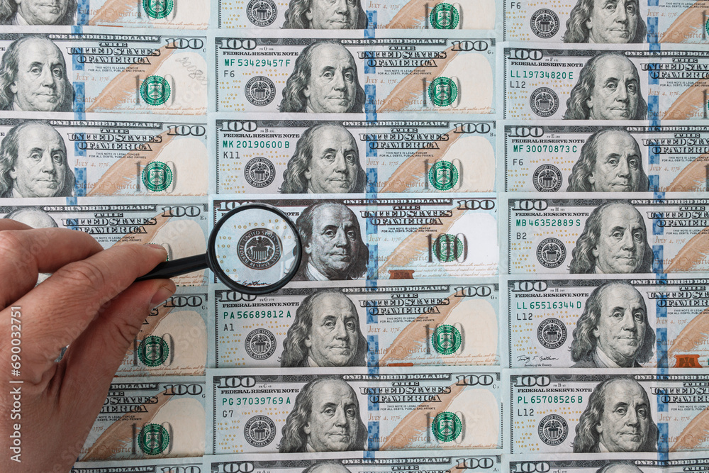 view money under a magnifying glass. Counterfeiter forges banknotes ...