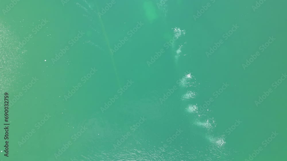 Retreating drone shot of a crsytal clear frozen lake's bubbling water ...