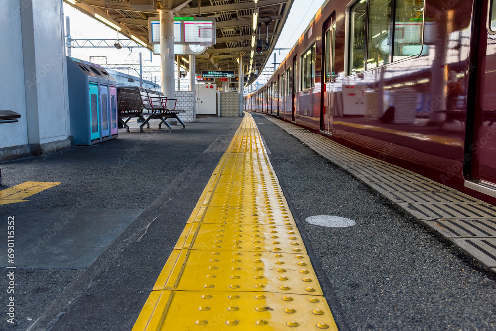 Straight Braille block for the visually impaired on pedestrian walkway at train platform in ...