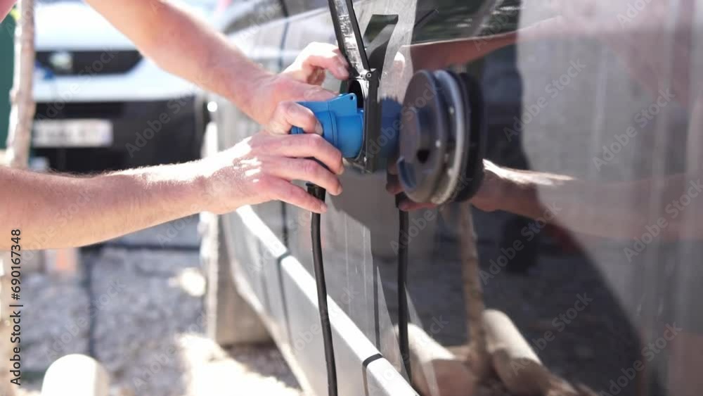 Hands of white man lifting lid cover of blue external plug. RV 240v ...