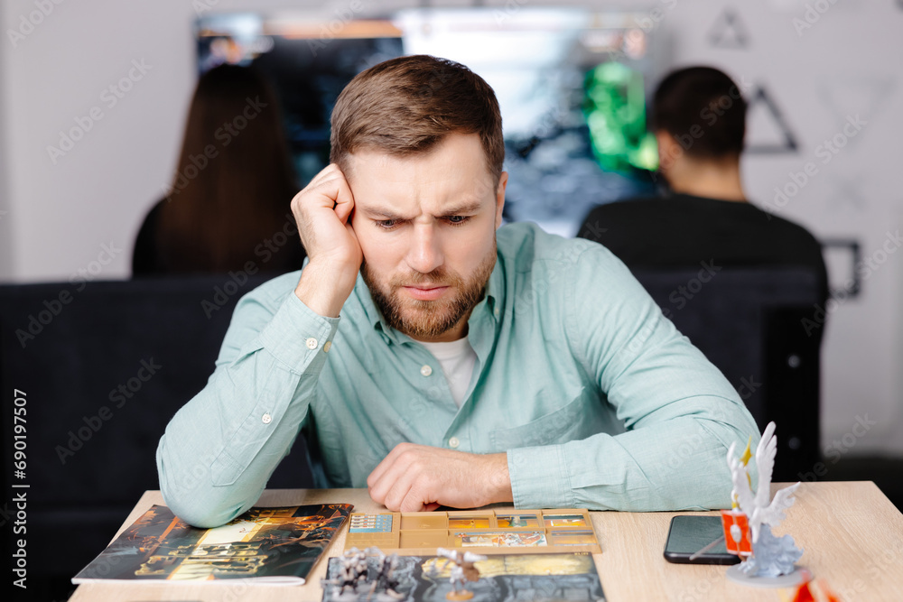 Man with board game piece while practicing strategy in home alone. A ...