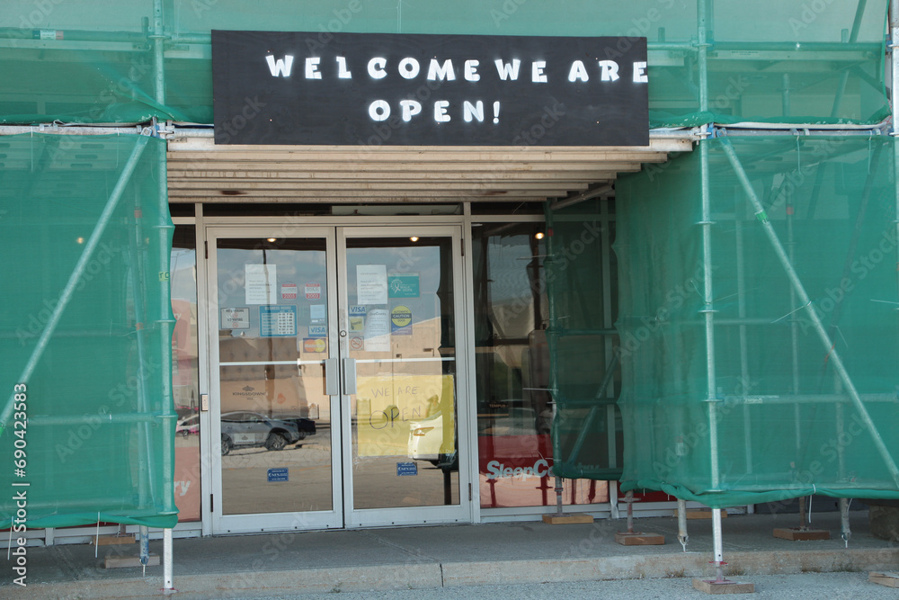 welcome we are open sign above store doors glass on canopy construction ...