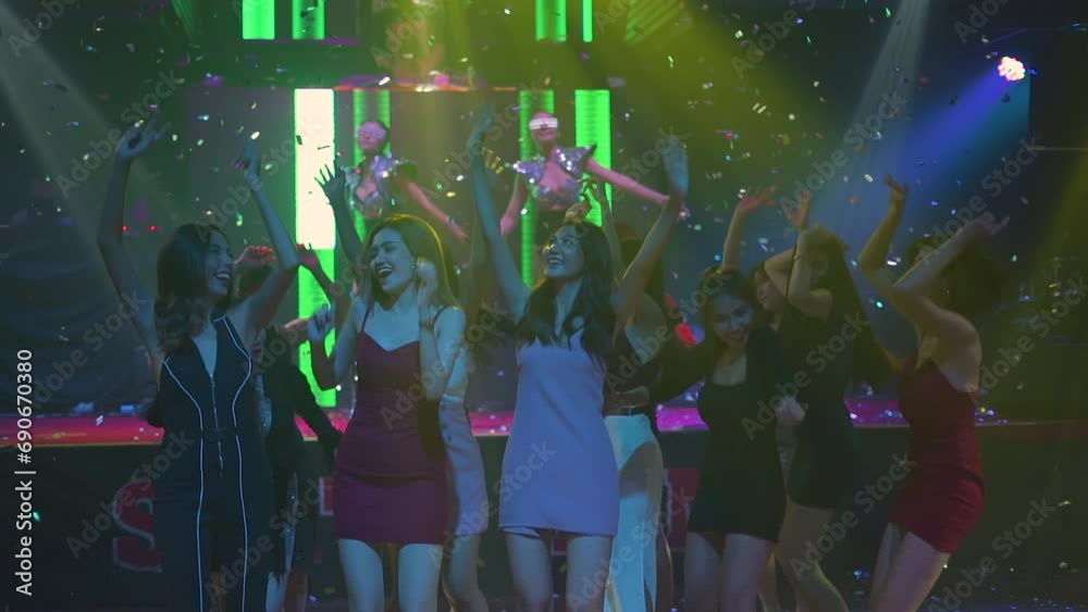 Cheerful young people dancing in night club with confetti at nightclub ...