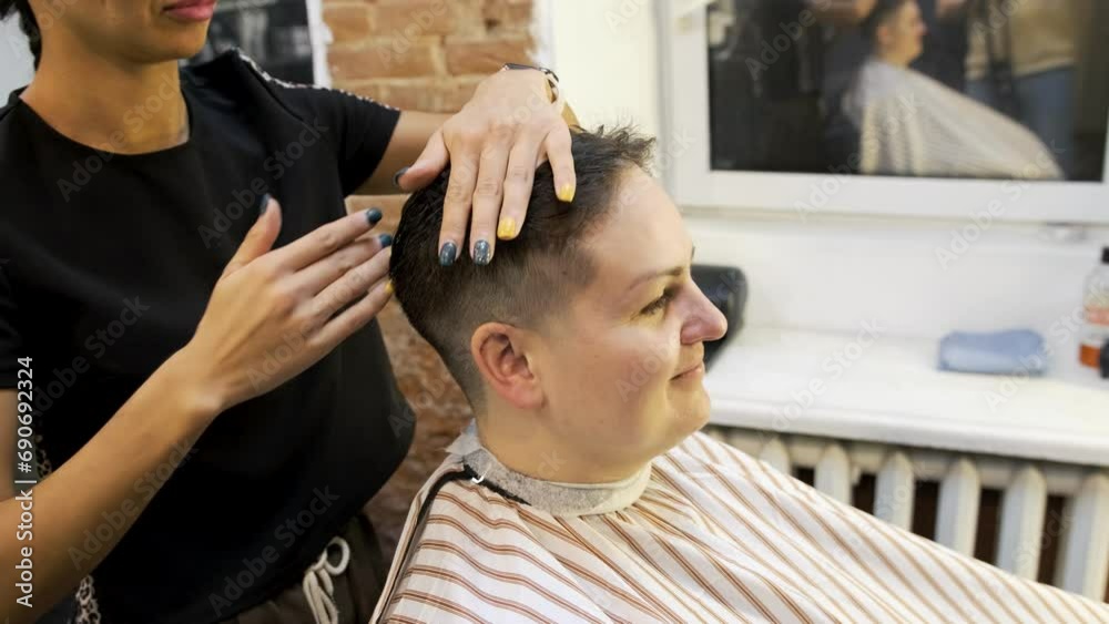 The hands of an asian hairdresser rub wax and form a hairstyle ...
