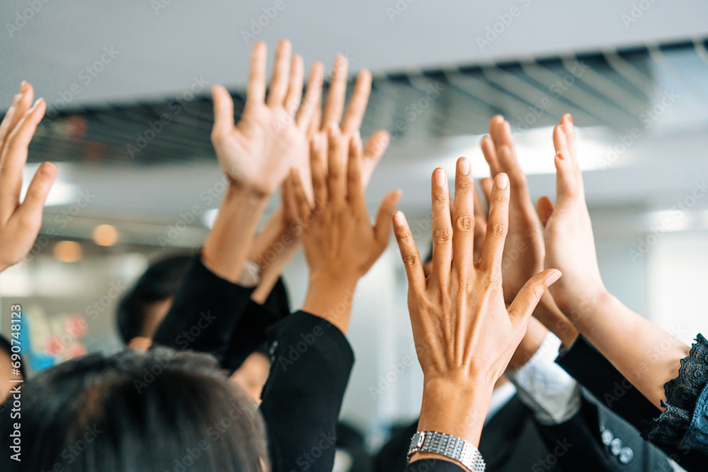 Many happy business people raise hands together with joy and success ...