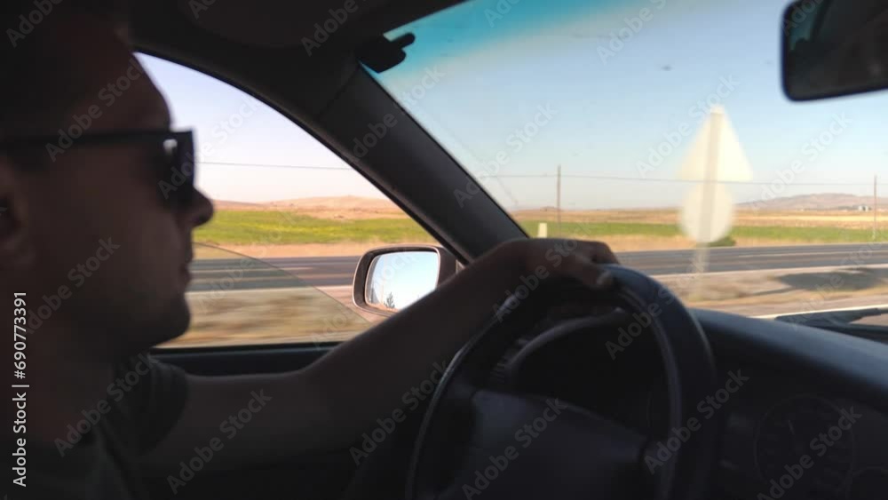 Man driving car side view inside cabin . Close-up of driver's hands ...