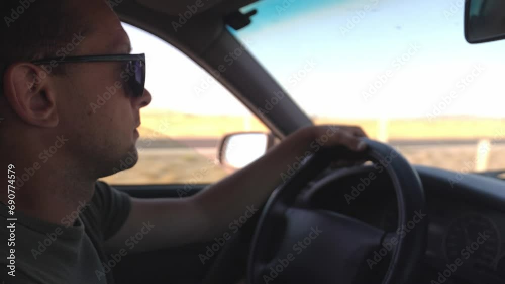 Man driving car side view inside cabin . Close-up of driver's hands ...