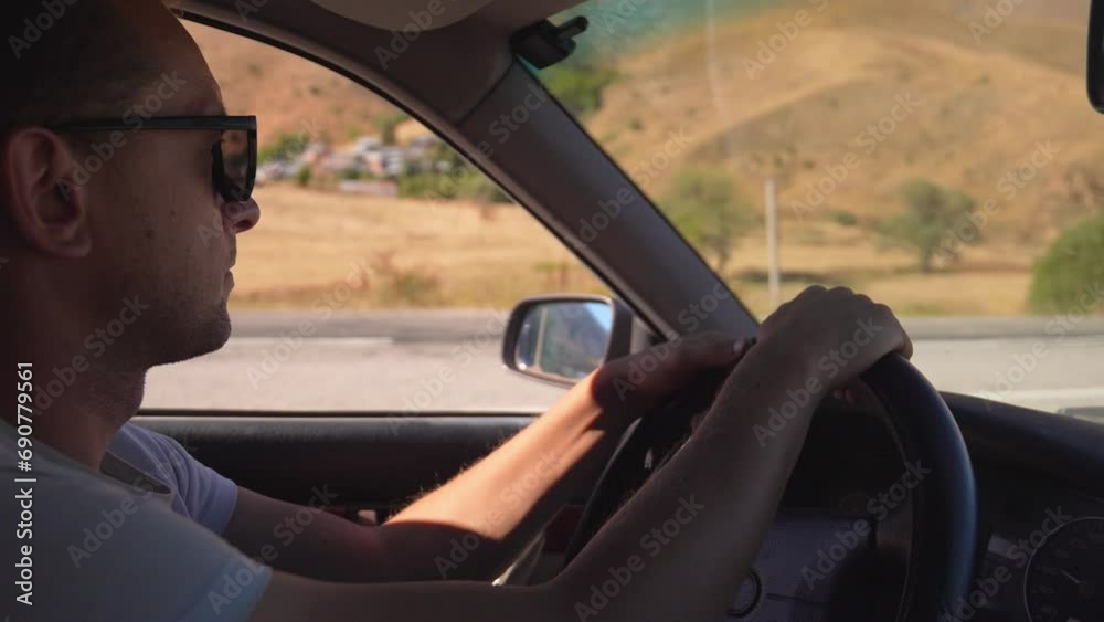 Man driving car side view inside cabin . Close-up of driver's hands ...