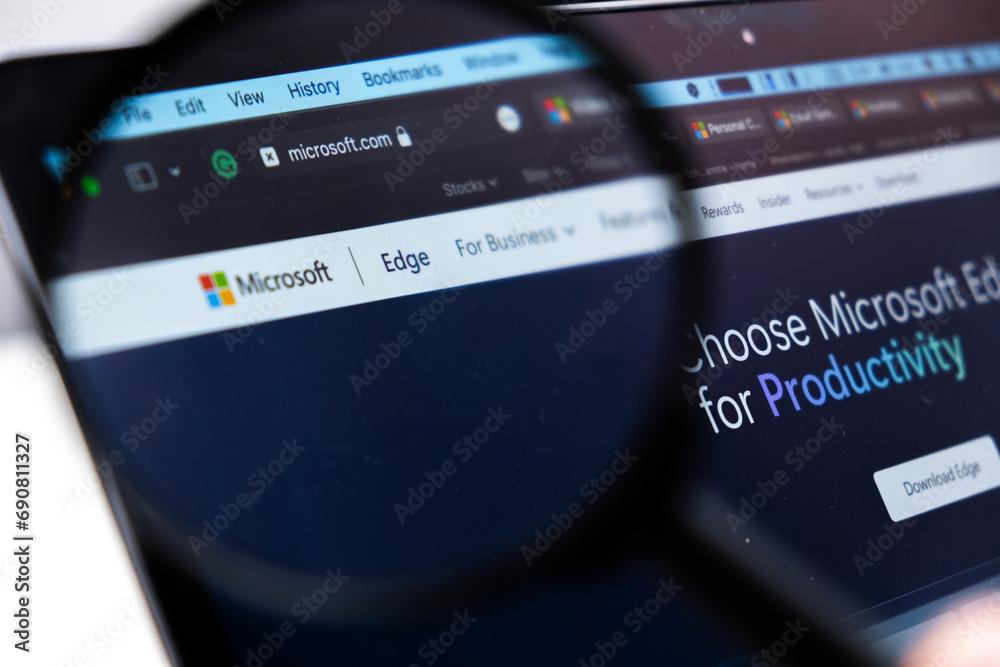 Microsoft Edge logo on the screen of laptop through magnifying glass ...