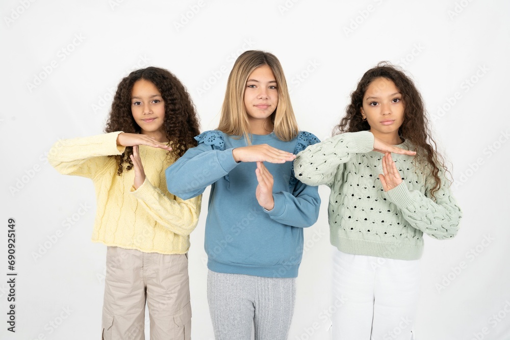 Three beautiful multiracial kid girls being upset showing a timeout ...