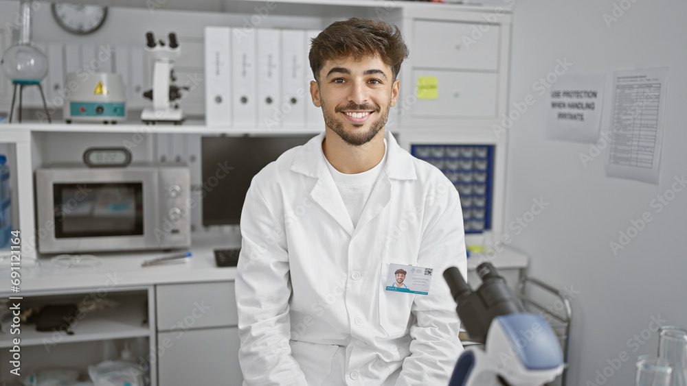 Confident young arab man, a smiling scientist, dives into research in ...