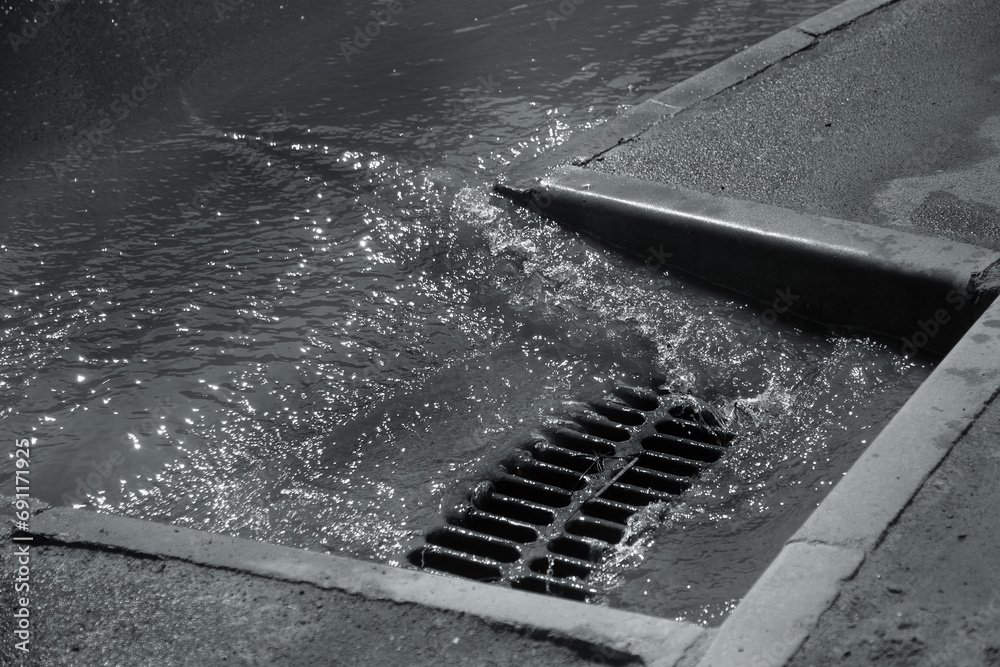 Flow of water during heavy rain and clogging of street sewage. The flow ...