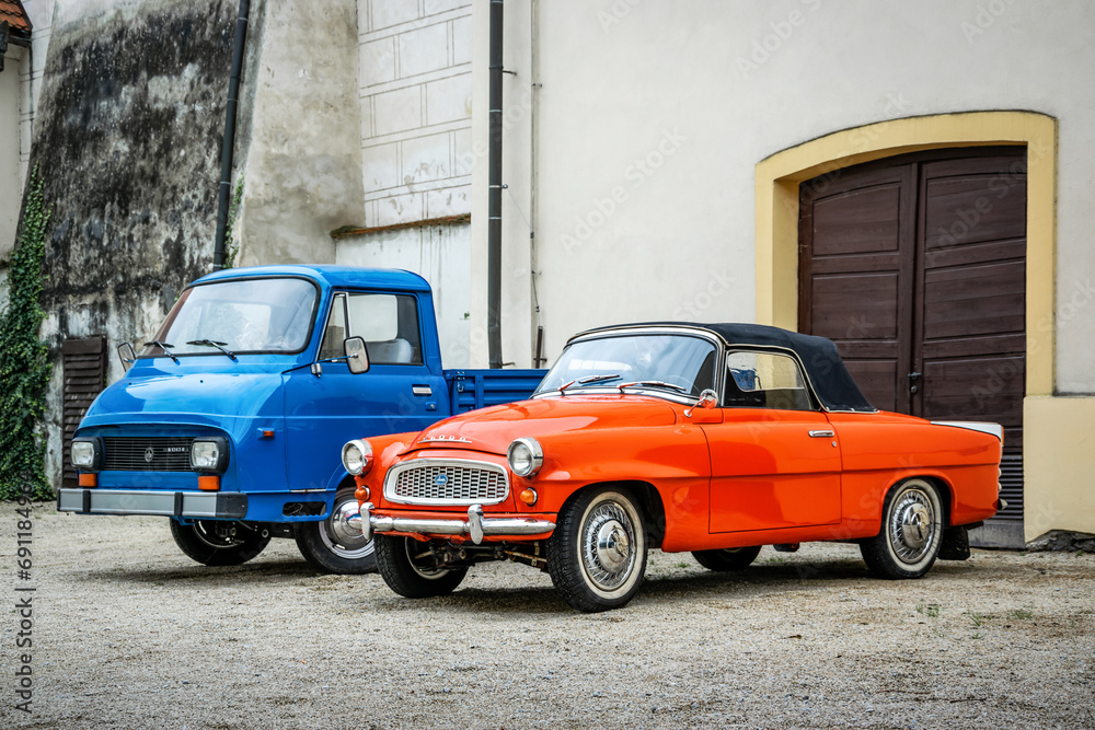 Two old cars park in the castle courtyard. The blue commercial car ...