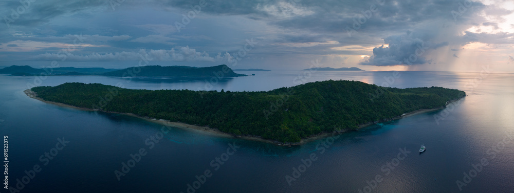 Early morning rain clouds drift near the beautiful island of Ambon ...