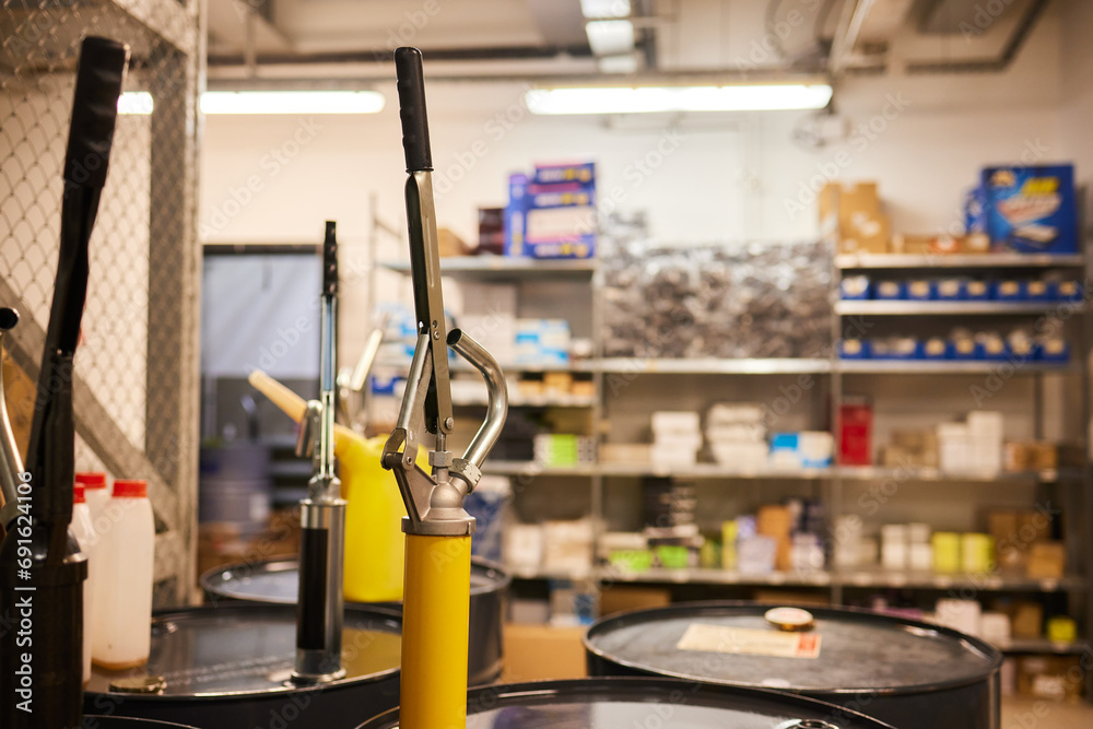 Motor oil in barrels with pump indoors with copy space. Store of lube ...