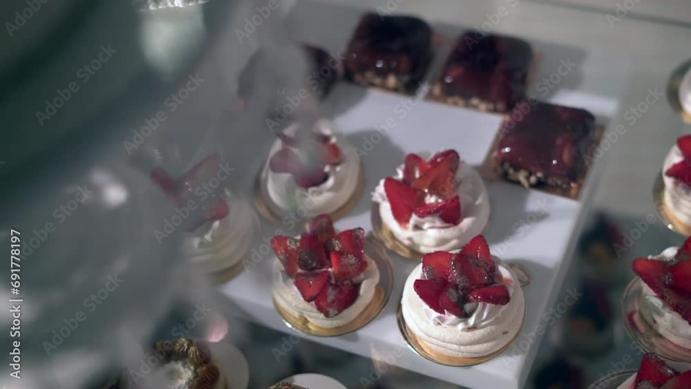 mini postres decorados con fresas en una mesa de postres de una fiesta ...