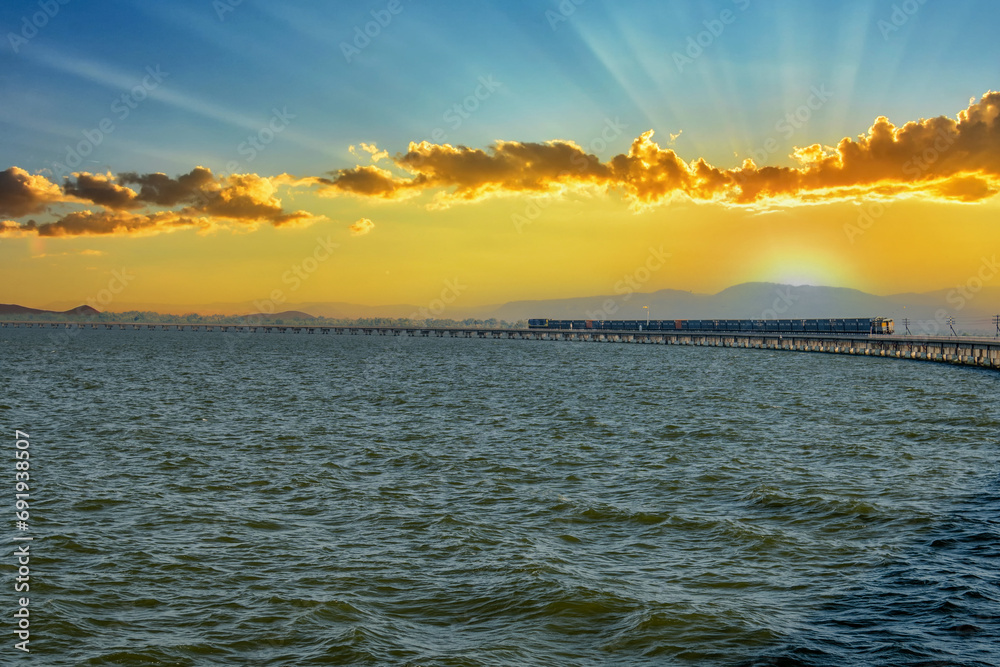 Thailand passengers train run on the floating railway bridge with blue ...