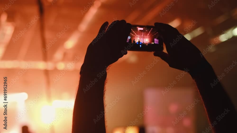 man's hands record video stories using a mobile phone. A crowd of fans ...