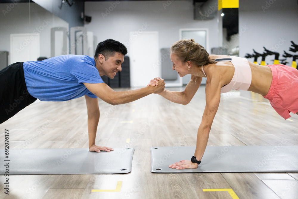 Fitness duo in plank position with motivational fist bump Stock Photo ...