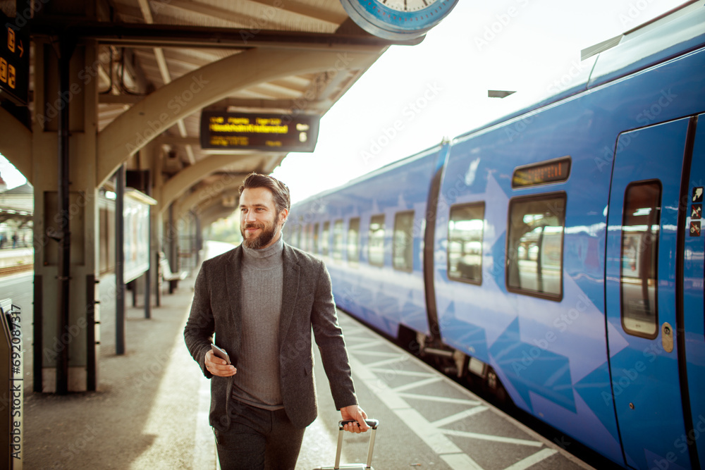 Professional young man in train station using smartphone Stock Photo ...