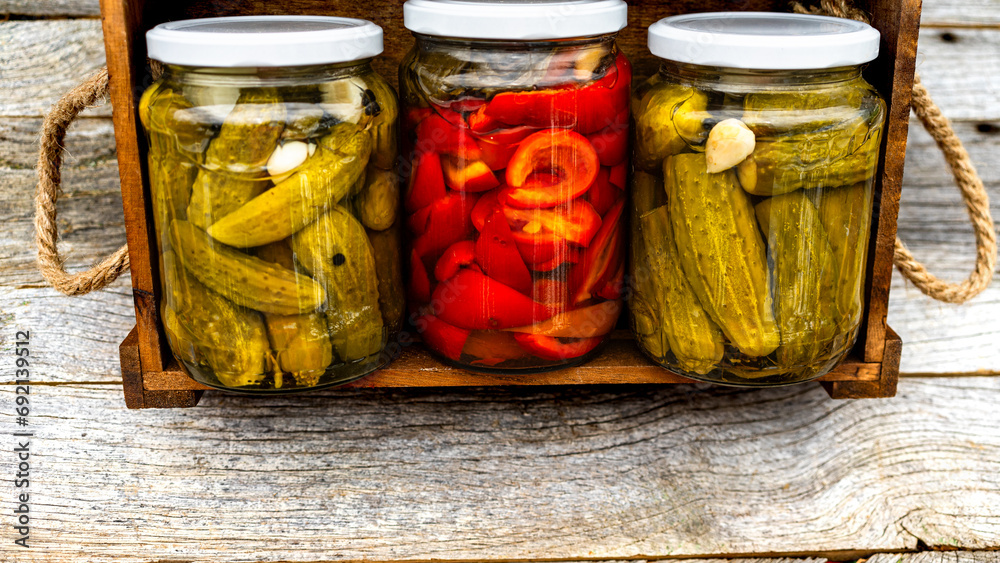 Glass jars with pickled red bell peppers and pickled cucumbers (pickles ...