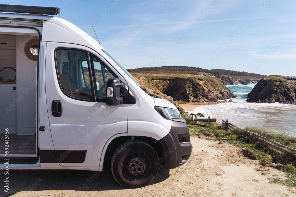 Elegant handcrafted camper van parked in front of the beach on the ...