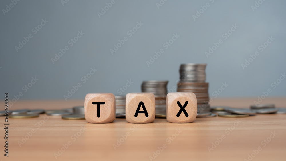 Tax wording print screen on wooden cube block and coins stacking for ...