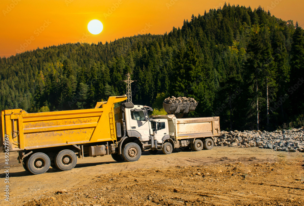 The excavator loads crushed stone in a dump truck body. Loading stones ...