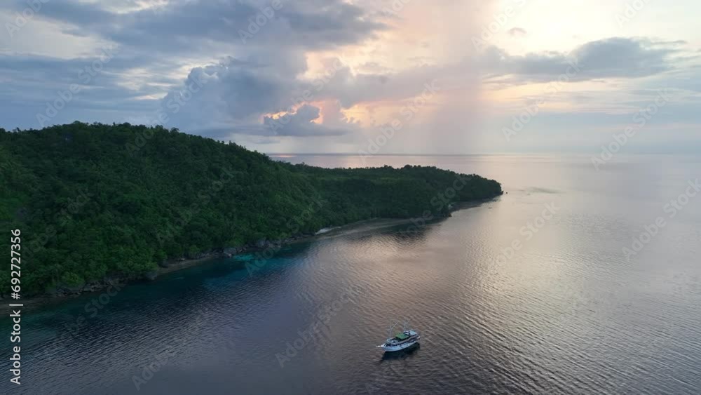 Early morning rain clouds drift near the beautiful island of Ambon ...