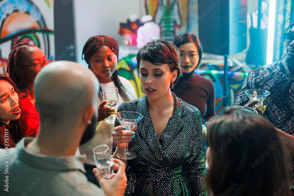 Woman holding alcohol drink glass and celebrating with friends together ...