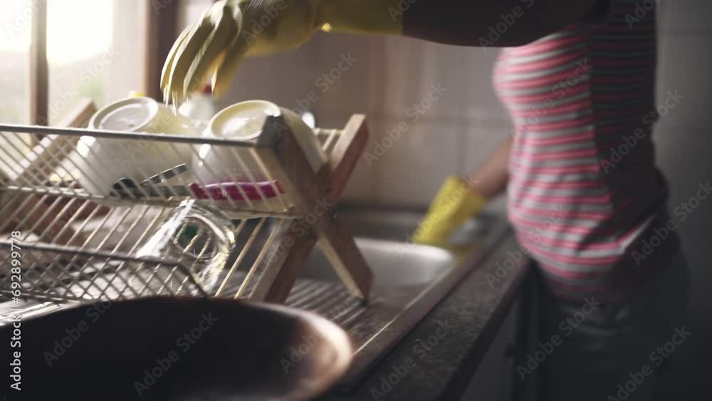Water, hands and woman washing dishes in a kitchen with gloves for ...