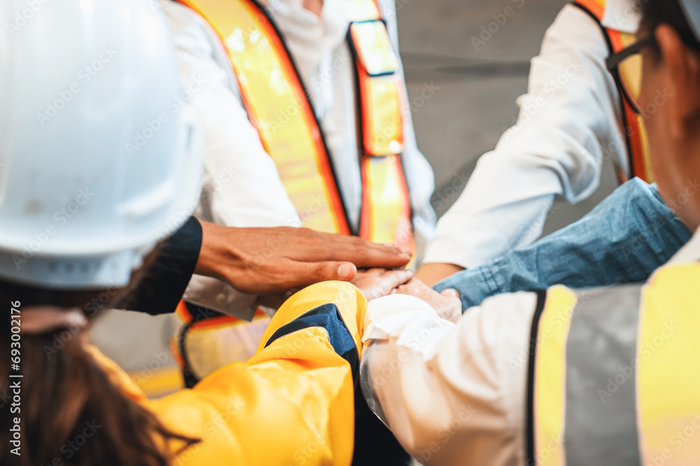Cohesive and united group of factory worker joining hands together in ...