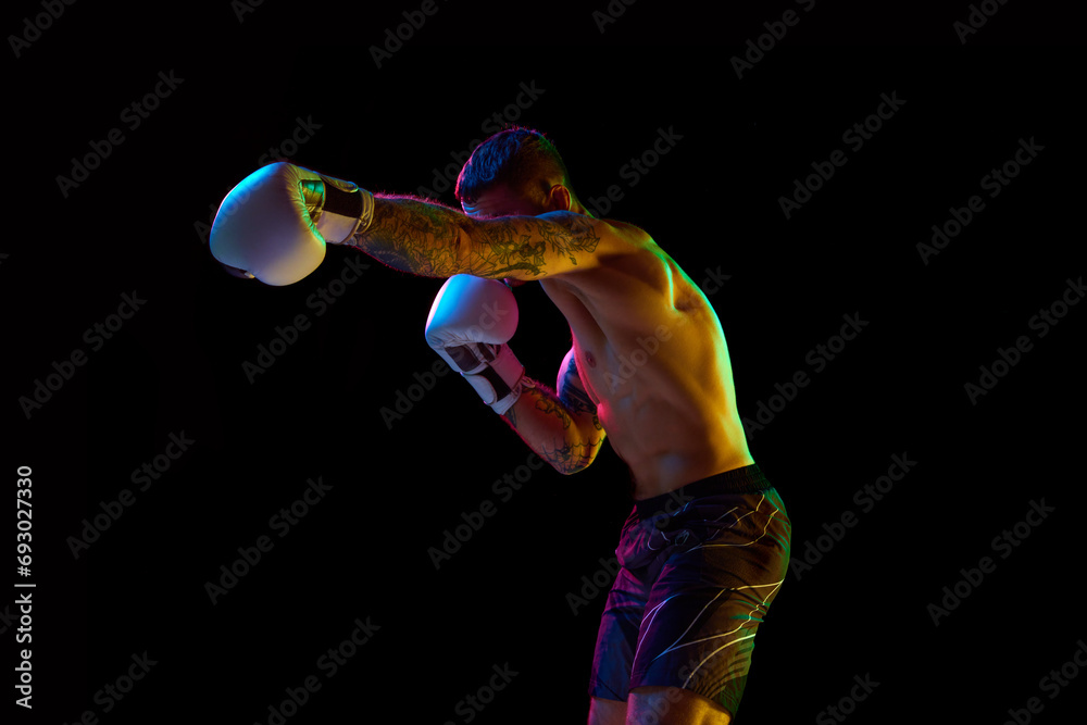Young muscular man, boxing athlete in motion, training, fighting on ...