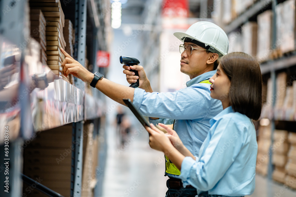 Warehouse staff working together using digital tablets to check the ...