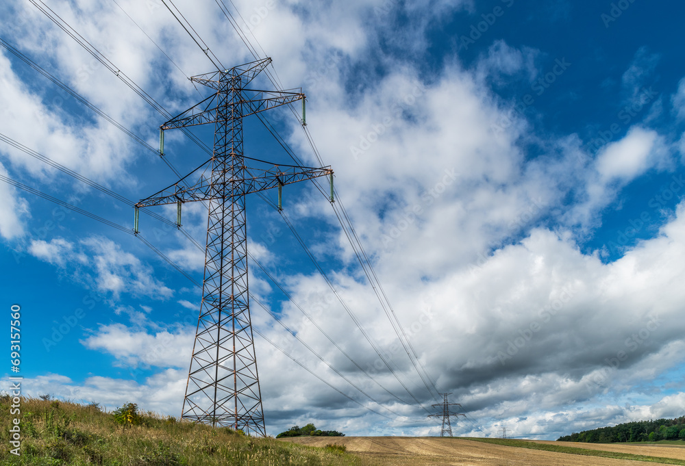 Electric power transmission line in nature scenery with blue sky and ...
