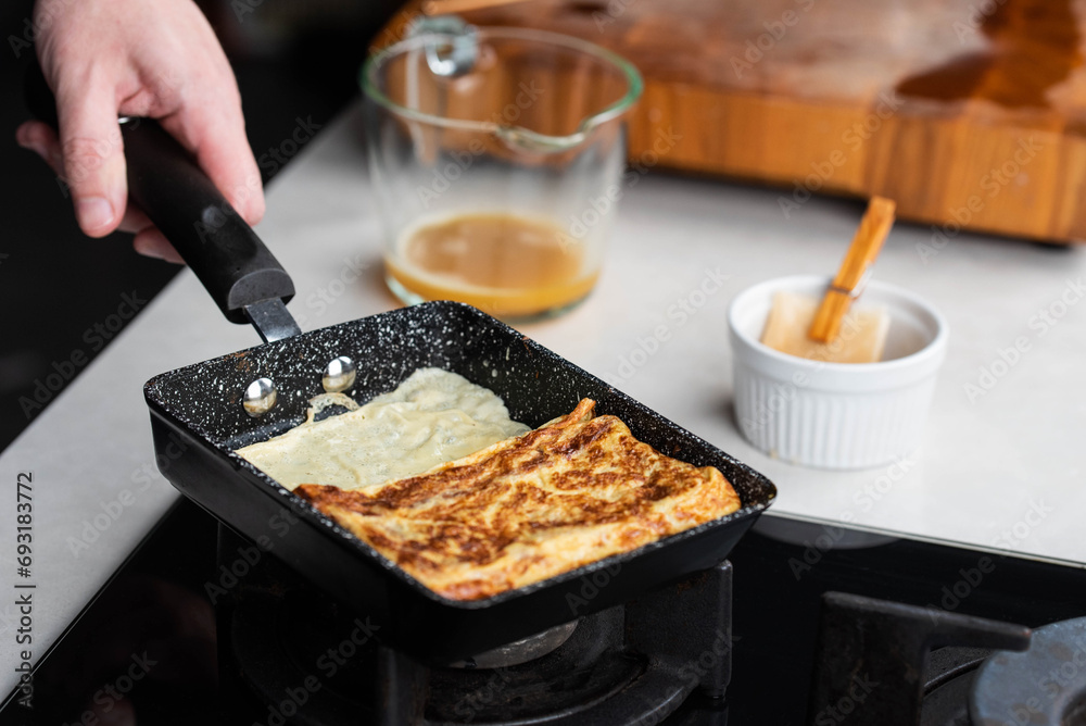 Chef man hands cooking Tamagoyaki or Tamago traditional Japanese Rolled ...