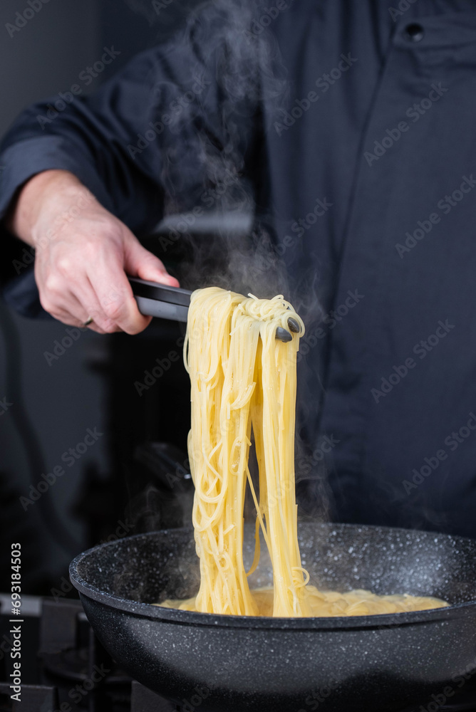Professional chef cooks making Italian Capellini spaghetti pasta at ...
